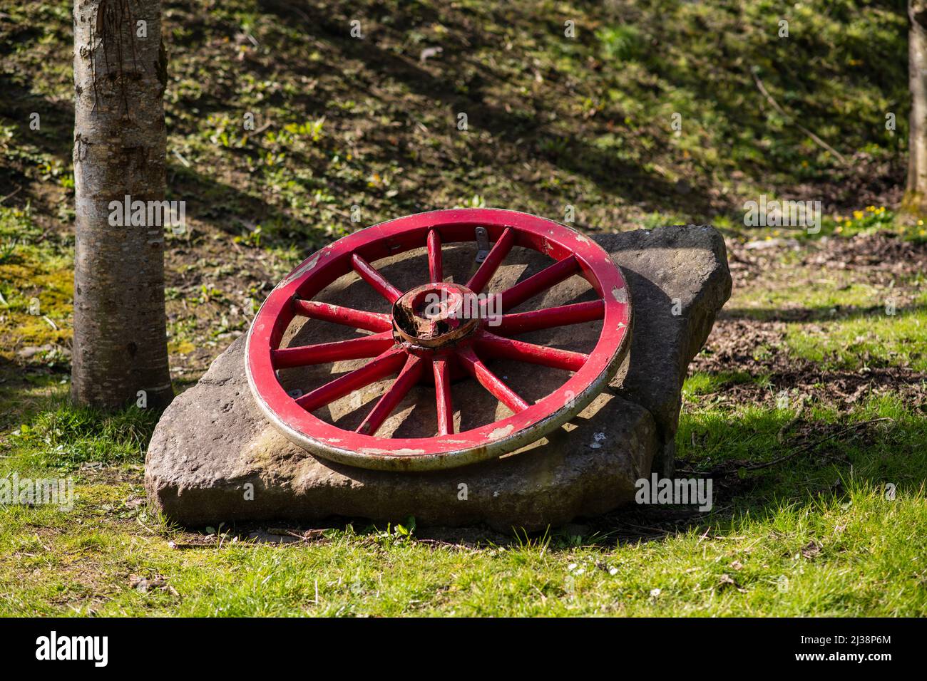 An old wooden wagon wheel leans against a stone Stock Photo - Alamy