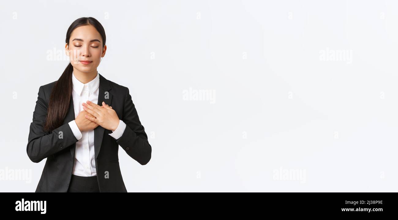 Happy dreamy asian female entrepreneur in suit close eyes and holding ...