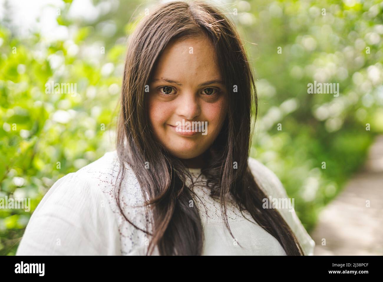 Portrait of trisomy adult outside having fun Stock Photo - Alamy