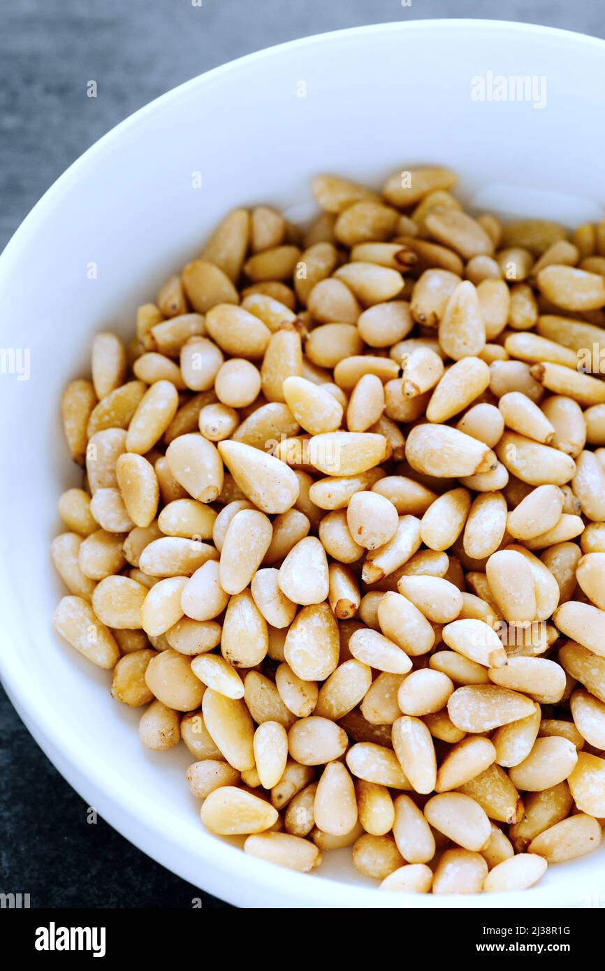 Pine nuts in white bowl Stock Photo - Alamy
