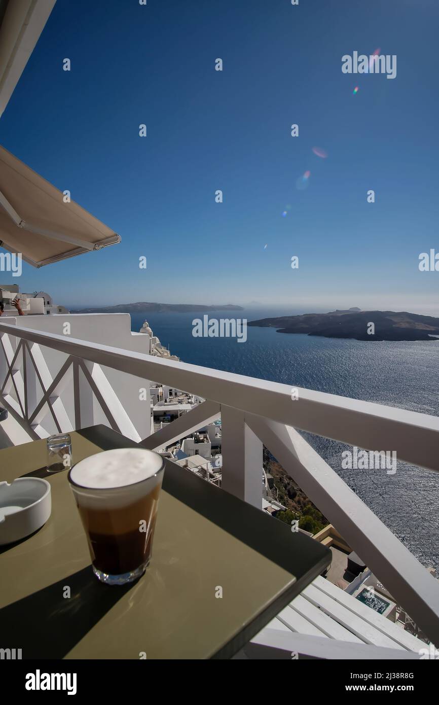 Panoramic view of the famous caldera and an iced greek coffee, also ...