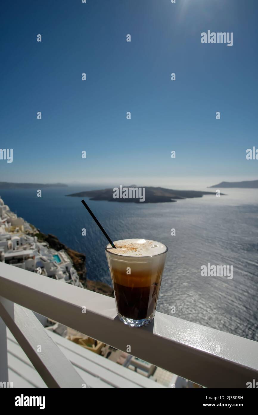 Panoramic view of the famous caldera and an iced greek coffee, also ...