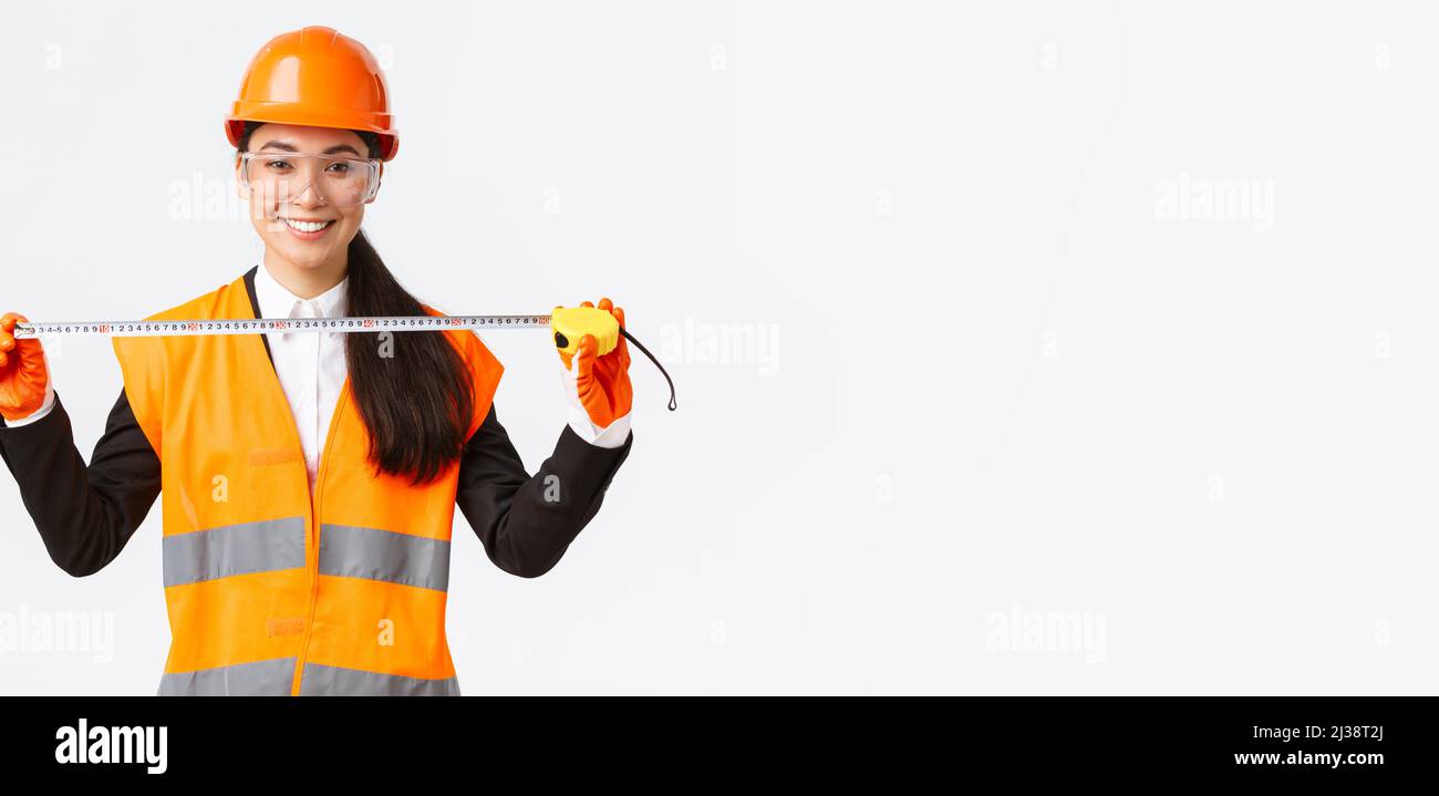 Confident professional female asian architect measuring layout, wearing ...