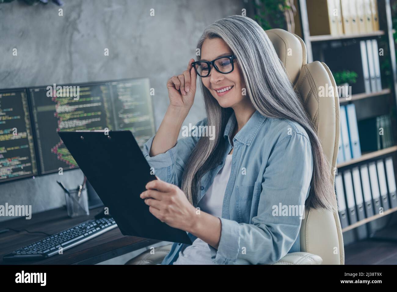 Photo of smart boss lady chief it sit desk read clip board document ...