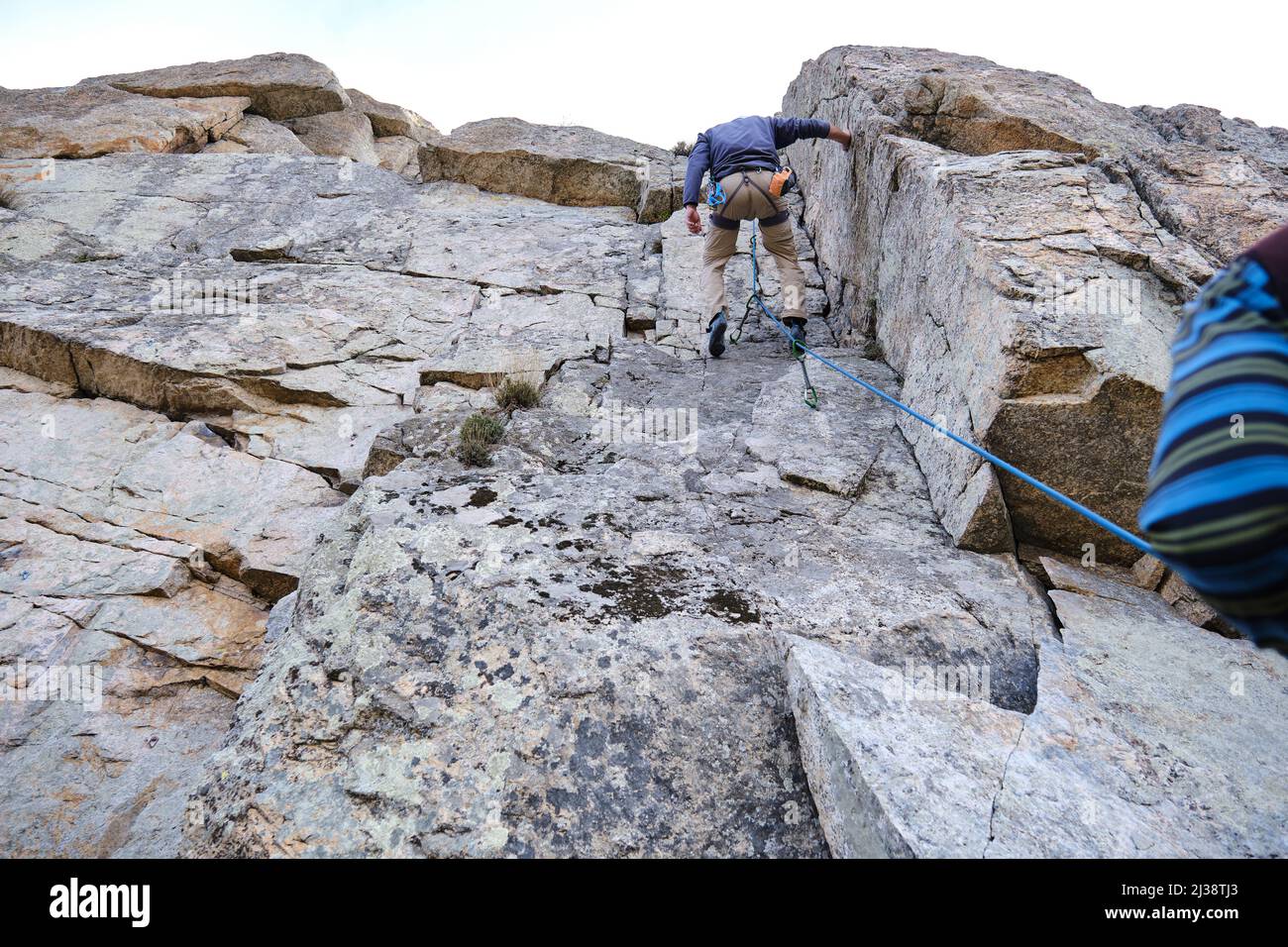 A Climber hanging from the rope descending a rock wall Stock Photo - Alamy