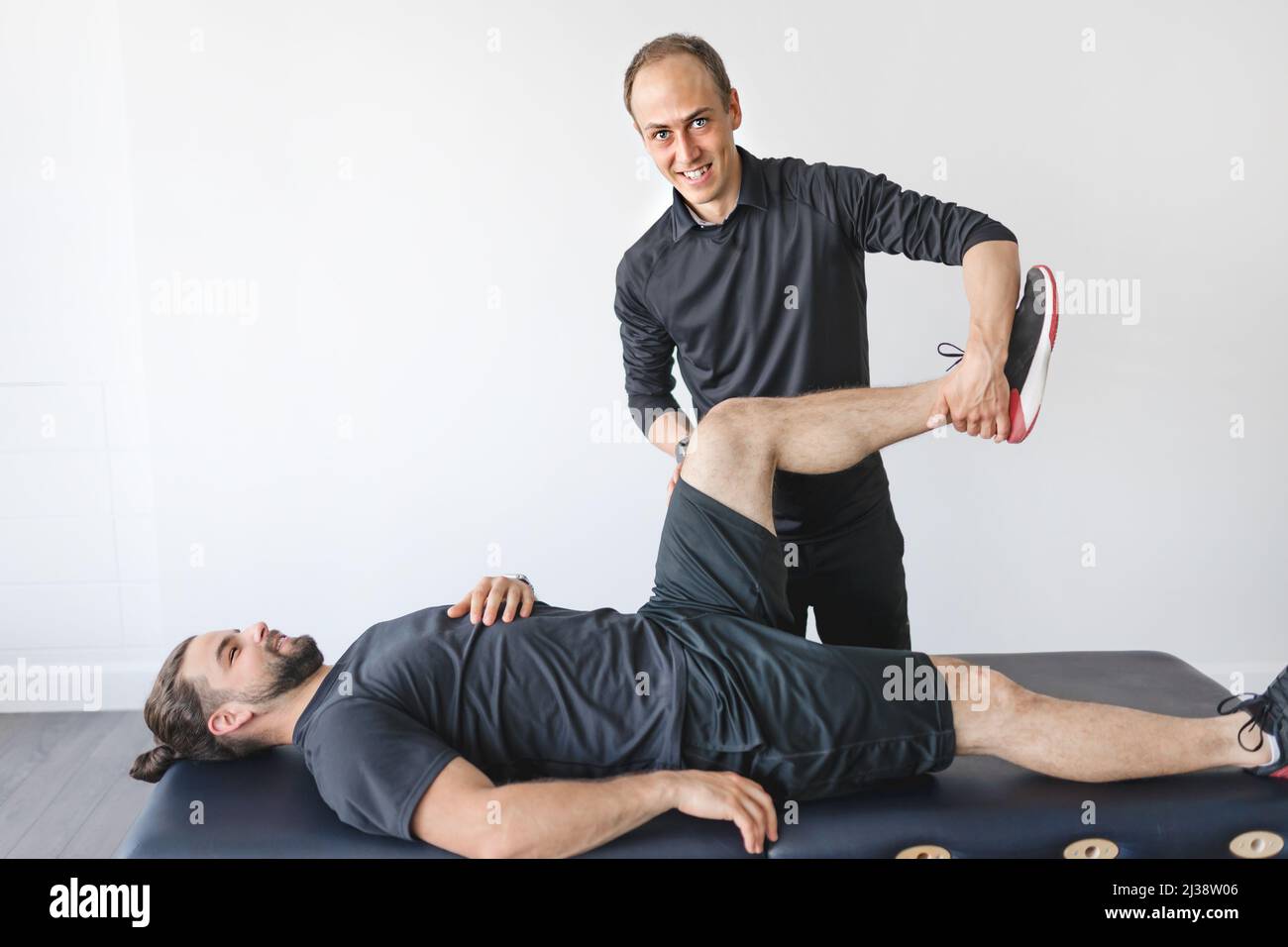 physiotherapist doing therapeutic exercises for patient at the clinic ...