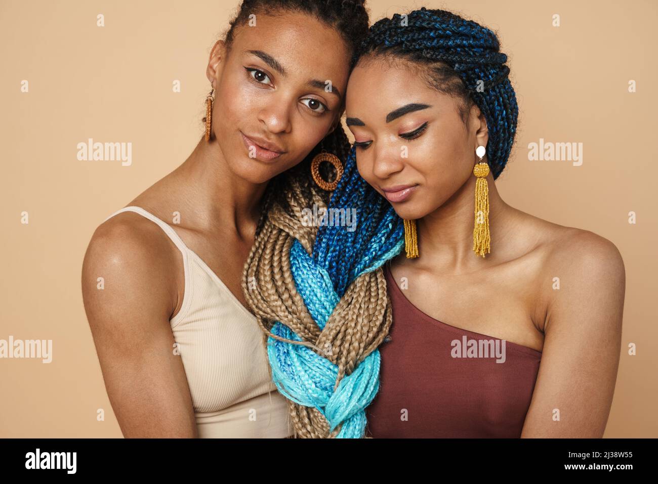 Young black two women hugging while posing on camera isolated over ...