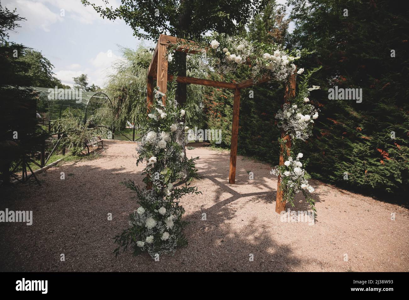 Rustic wedding arch for an ceremony decorated with white and flowers ...