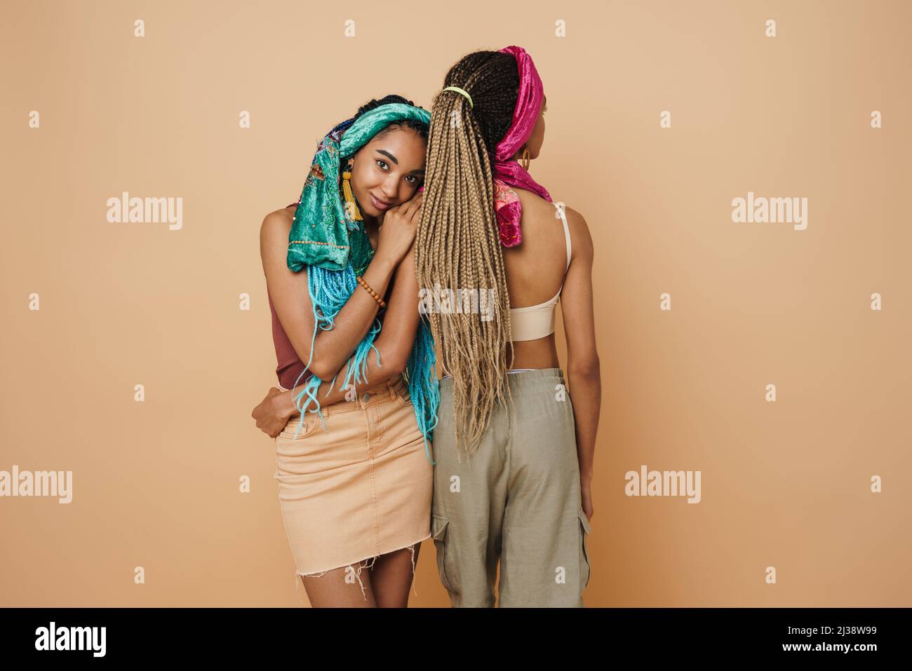 Young black two women hugging while posing on camera isolated over ...