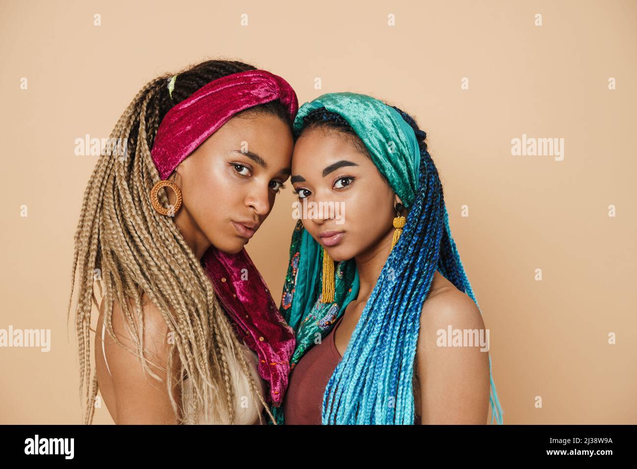 Young black two women with afro pigtails posing with head to head ...