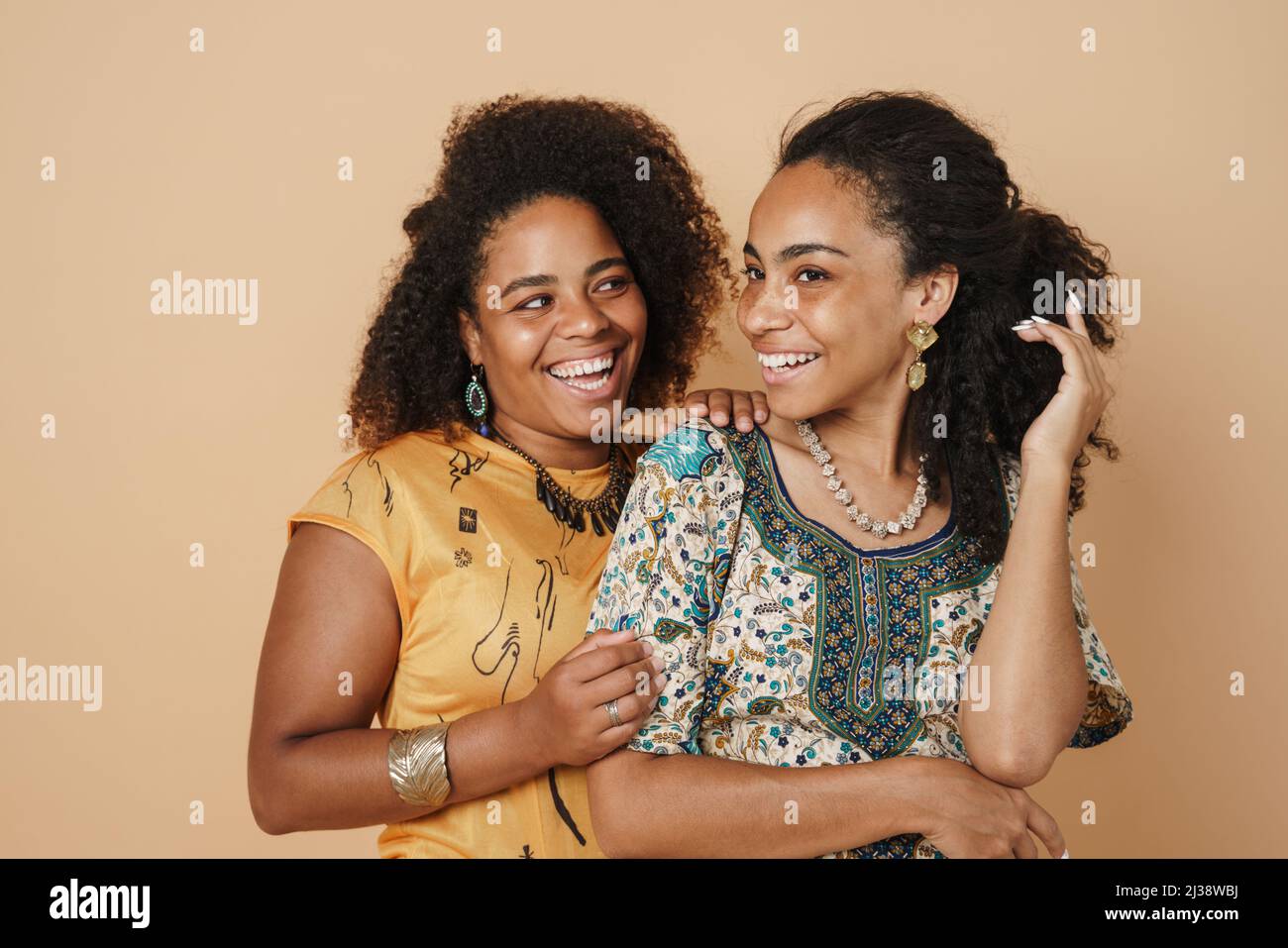 Young black two women hugging and laughing at camera isolated over ...