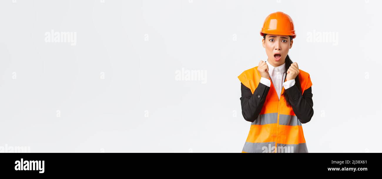 Scared asian female engineer in panic looking shocked and afraid ...