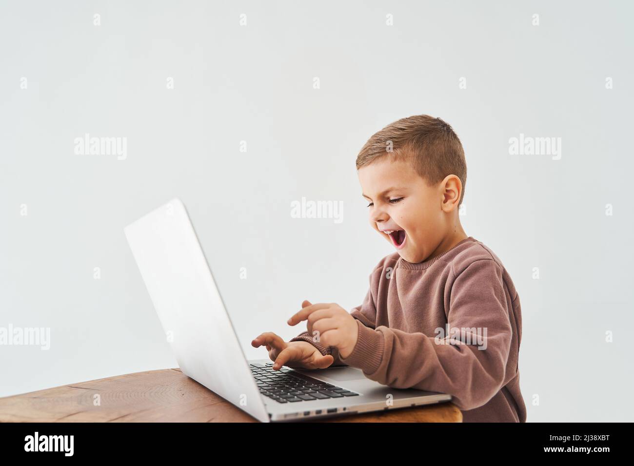 Emotional child play online games on laptop. Gambling addiction ...