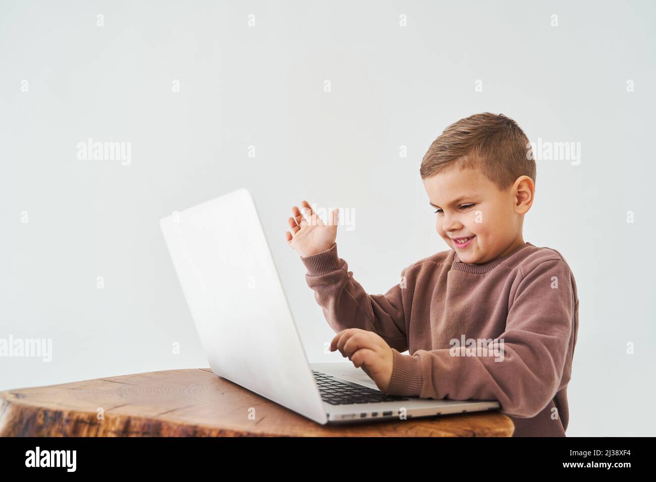 Emotional child with laptop talking with friends online. Handsome kid ...