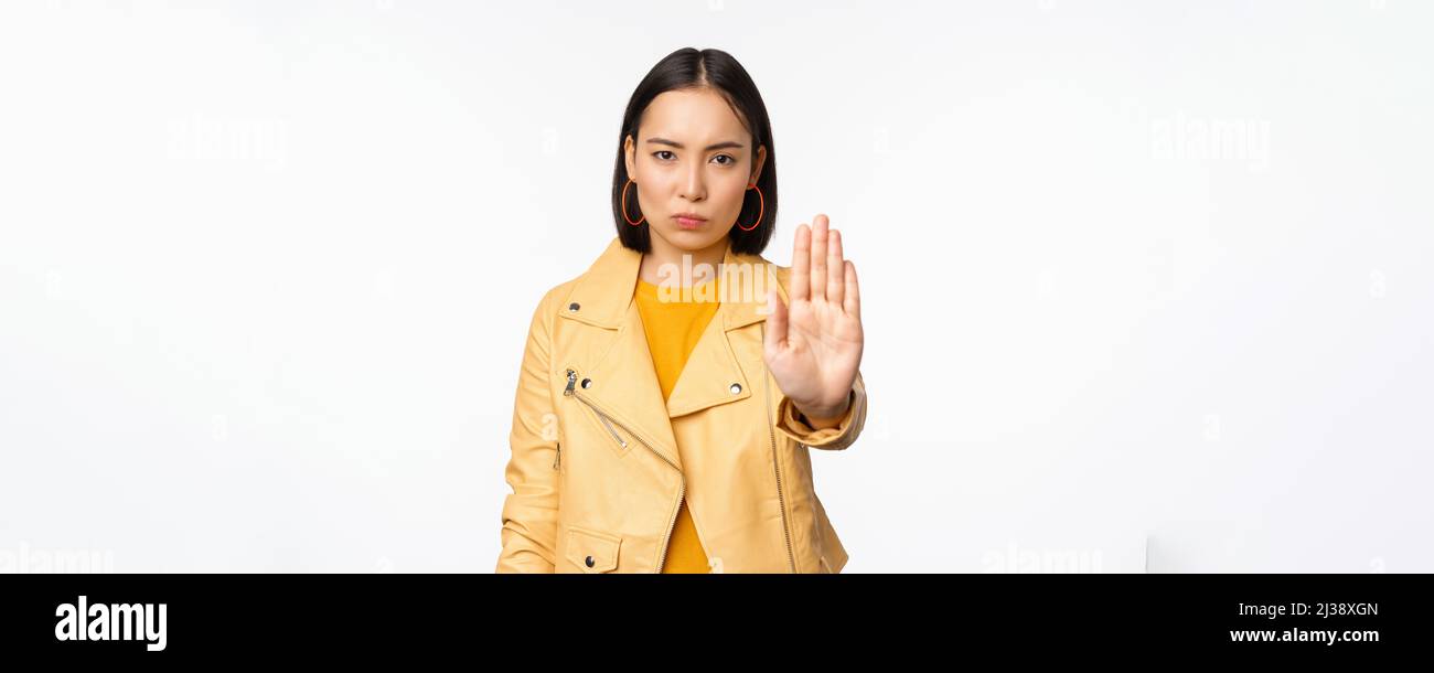 Serious and concerned asian girl extending palm hand, stop gesture ...