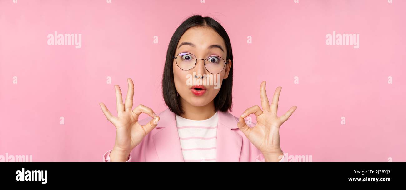 Close up portrait of business woman looks impressed and shows okay sign ...
