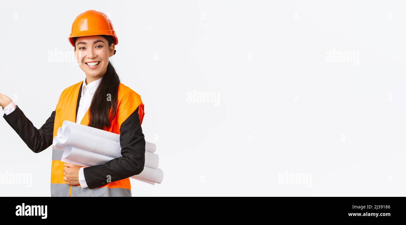 Smiling professional asian female architect, engineer in safety helmet ...