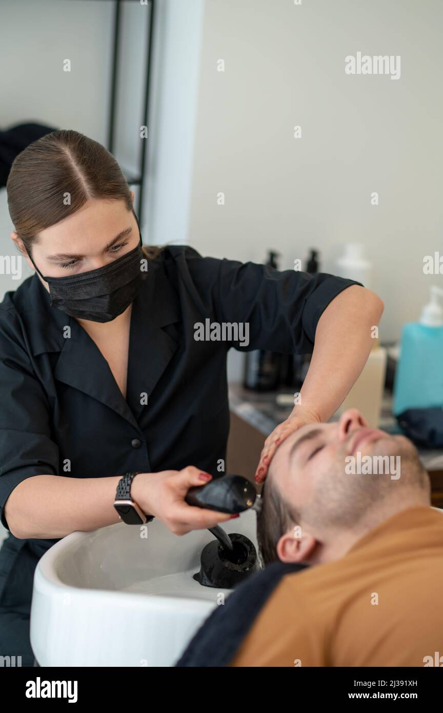 Female hairdresser washing hair to the customer Stock Photo - Alamy