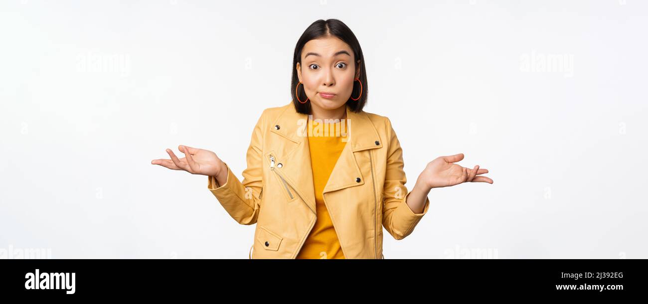 Image of korean girl shrugs shoulders and looks confused, dont know ...