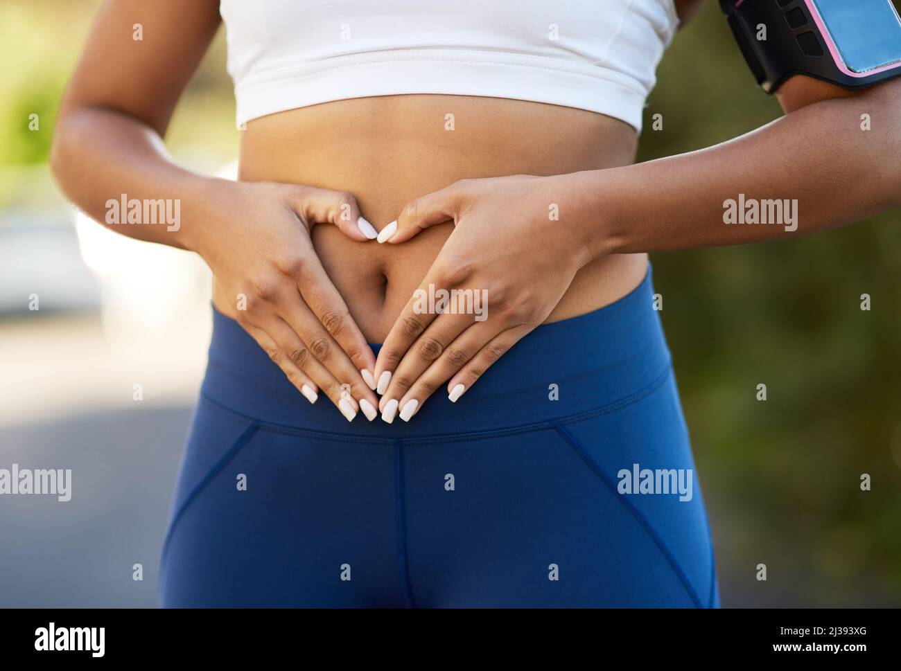 Love your body. Shot of an unrecognizable young woman making a heart ...