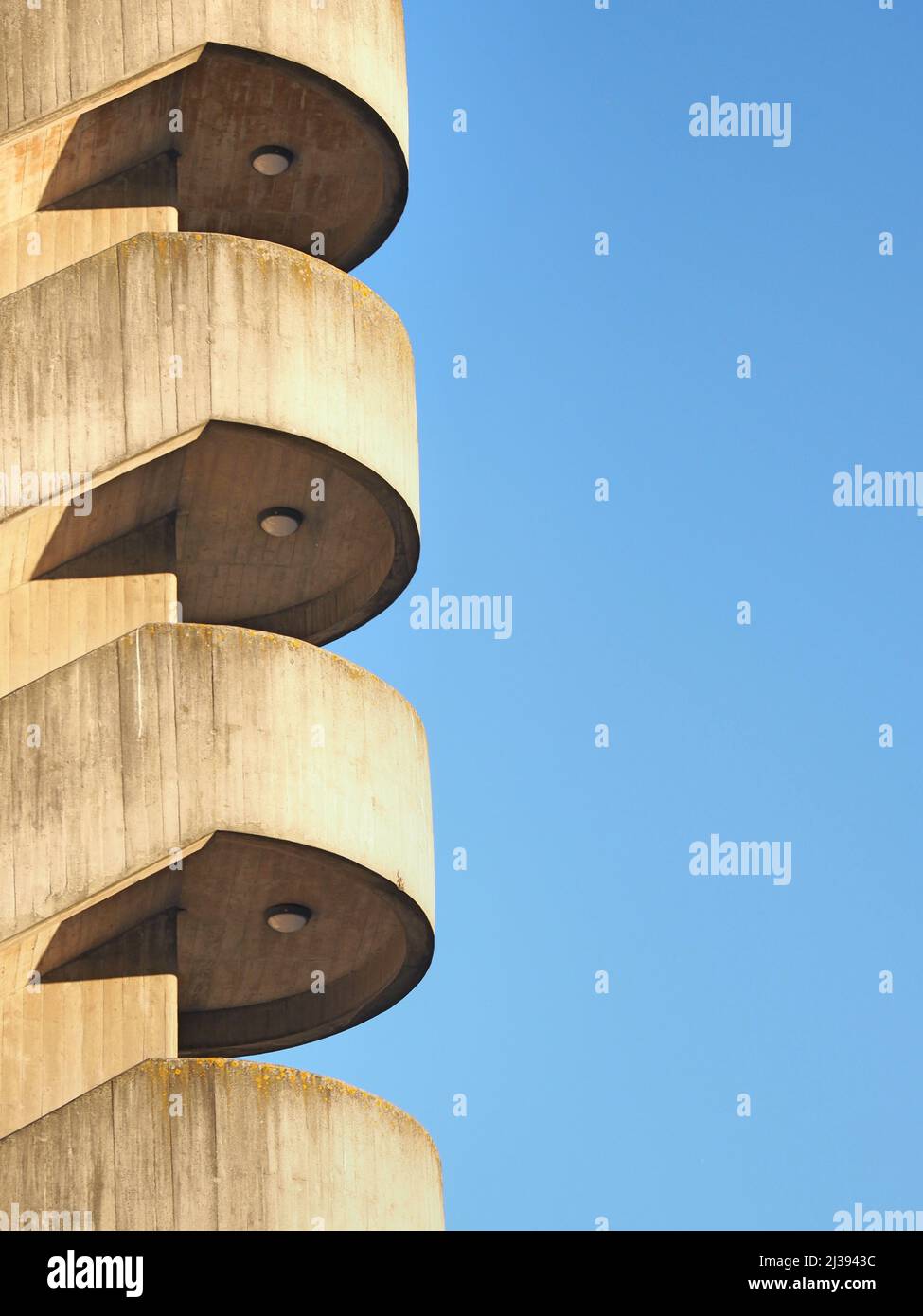 A vertical shot of an open-air building's staircase in the background ...