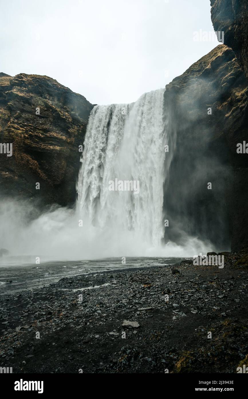 A vertical shot of a waterfall coming out of a huge cliff Stock Photo ...