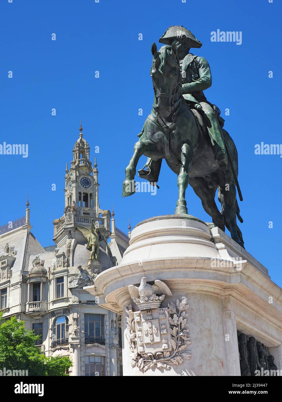 A vertical bottom shot of a sculpture in the background of buildings ...