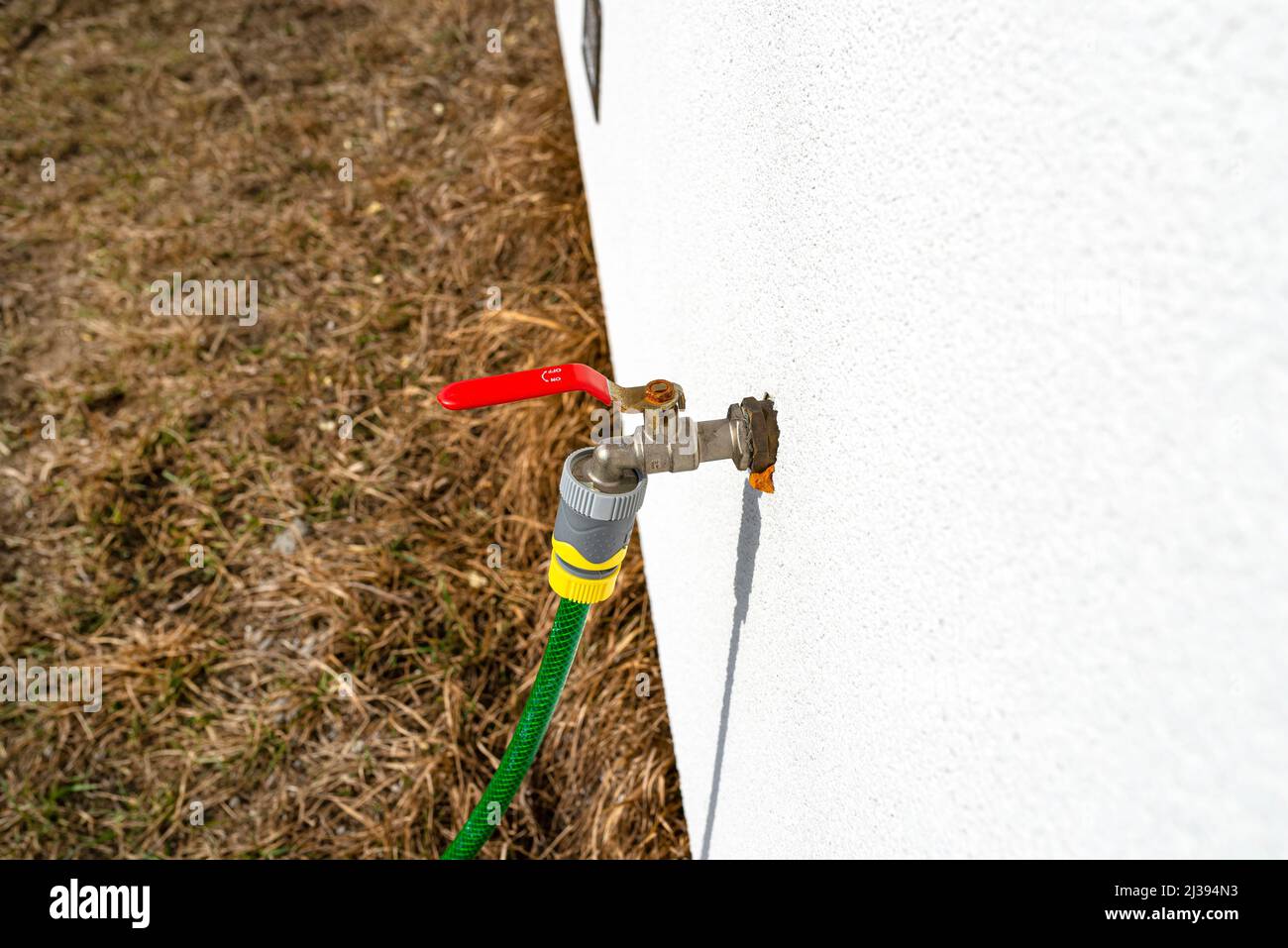 The tap protruding from the wall of the facade in the open position ...