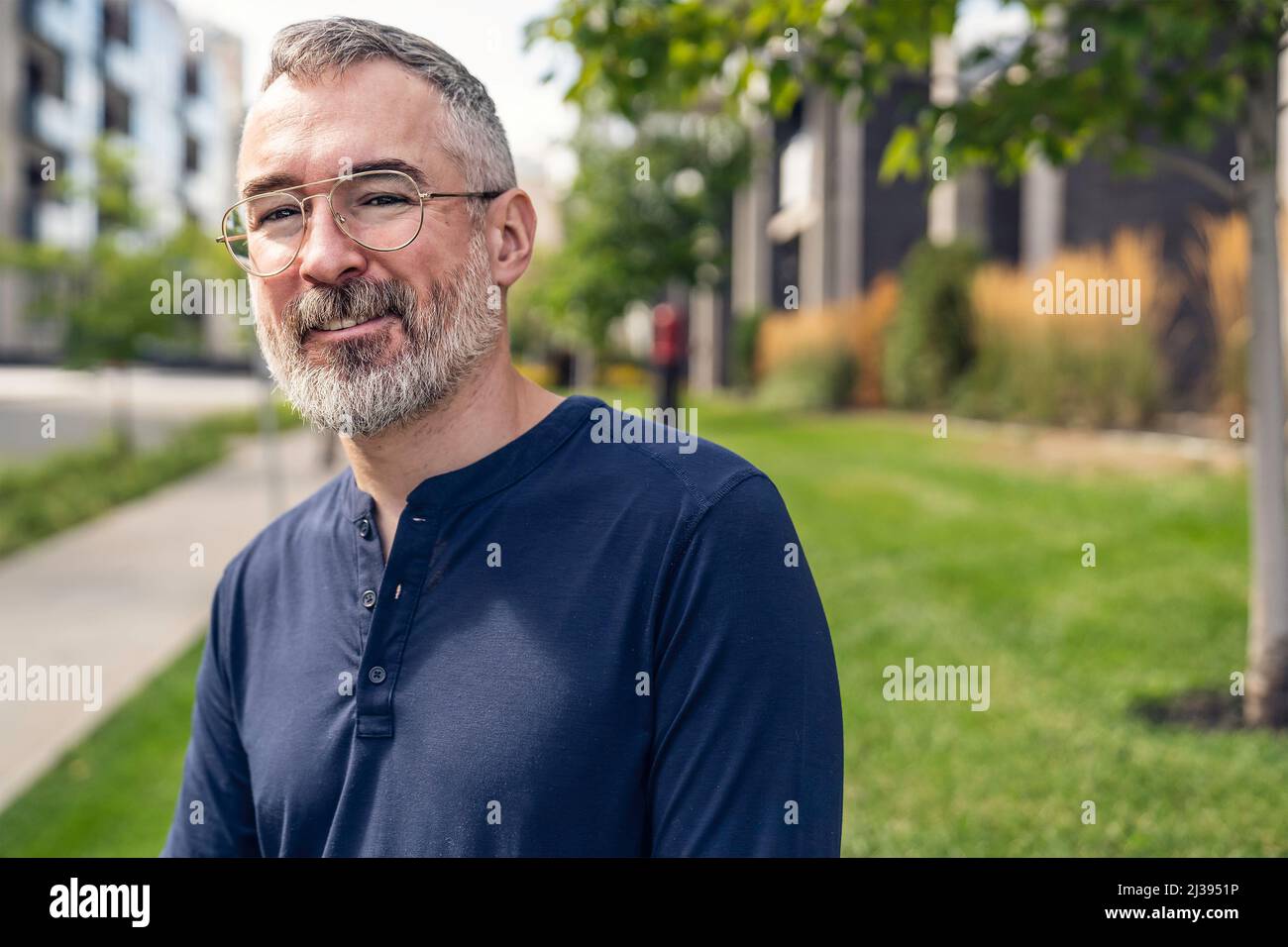 Mature man walking outside in city background Stock Photo - Alamy