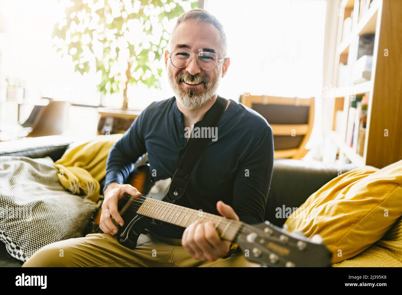 A attractive and relaxed looking man playing the guitar Stock Photo - Alamy