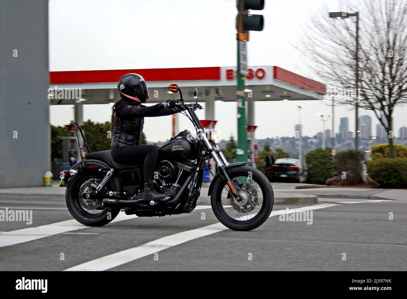 A young woman riding a classic Harley Davidson motorcycle in Burnaby ...