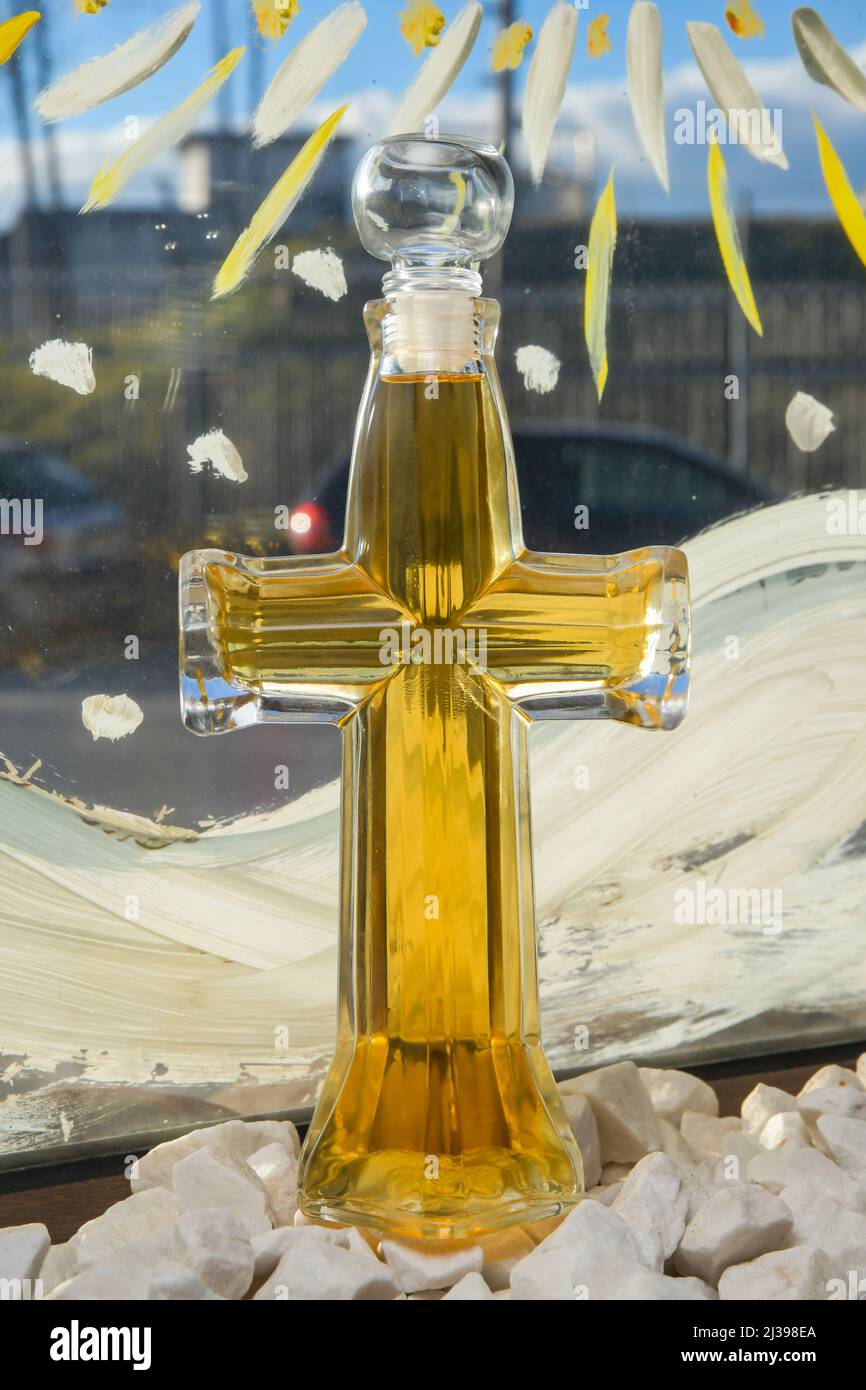 Yellow homemade brandy in a cross-shaped glass bottle Stock Photo - Alamy