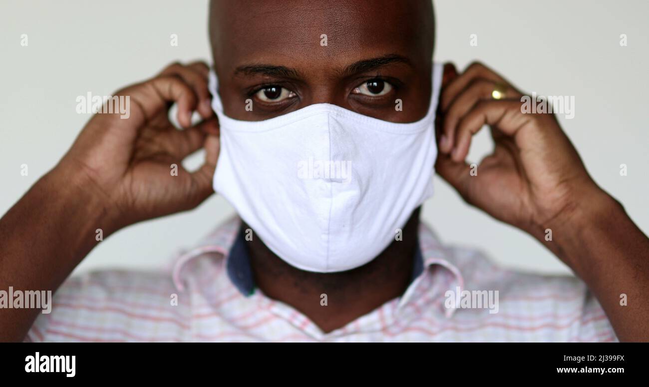 African man covering face with mask to protect from bacteria and ...