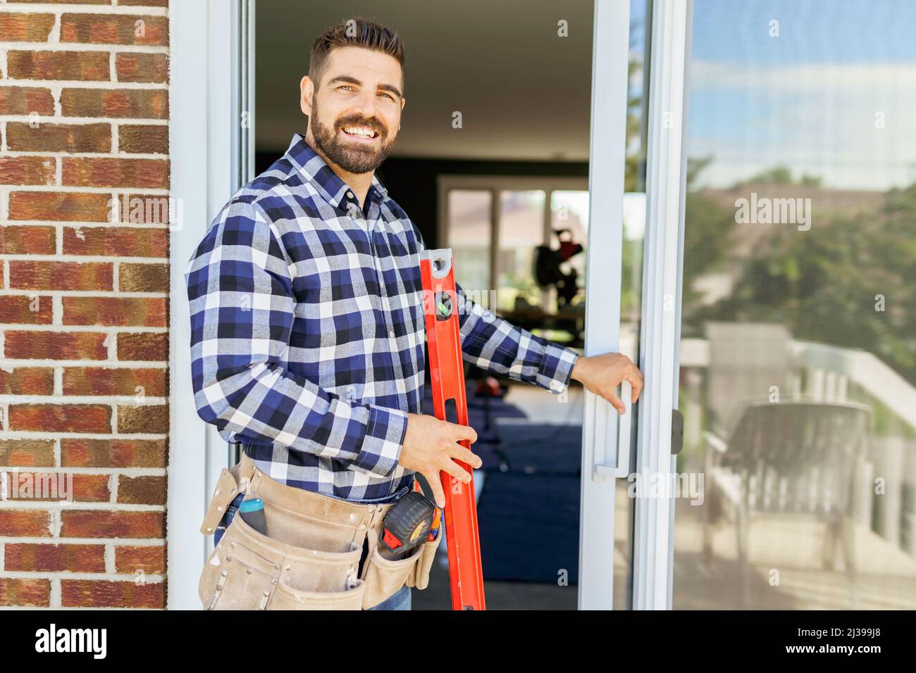 handsome young man installing bay window in a new house construction ...