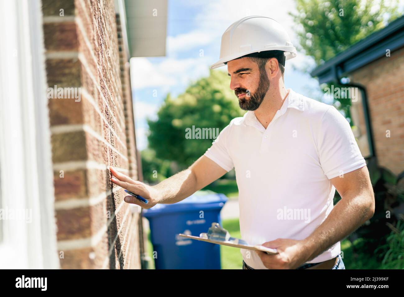 man with a white hard hat holding a clipboard, inspect house Stock ...