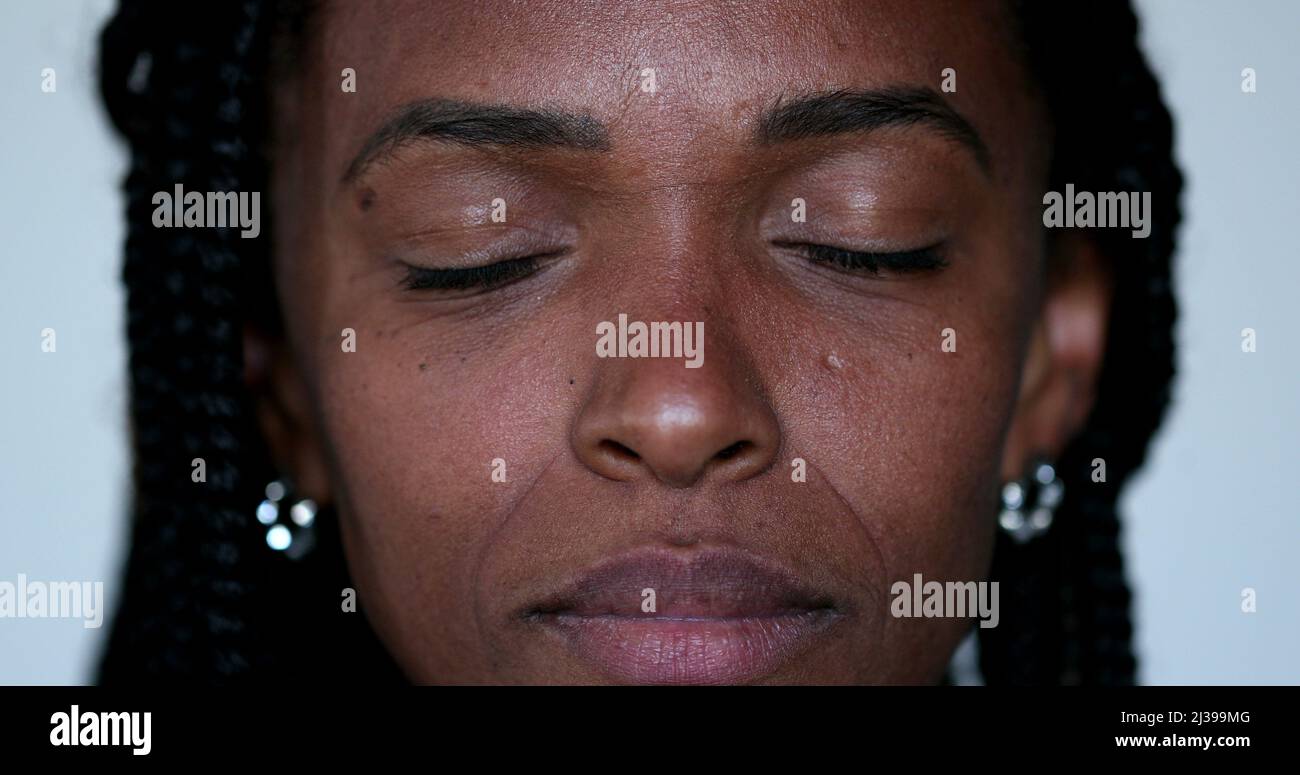 African woman closes eyes in meditation, close-up portrait face closing ...