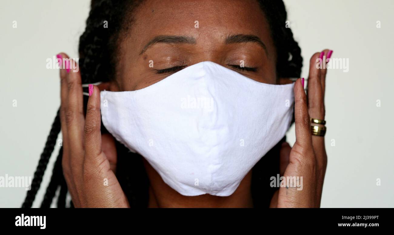 African woman taking off covid-19 face mask, end of outbreak concept ...