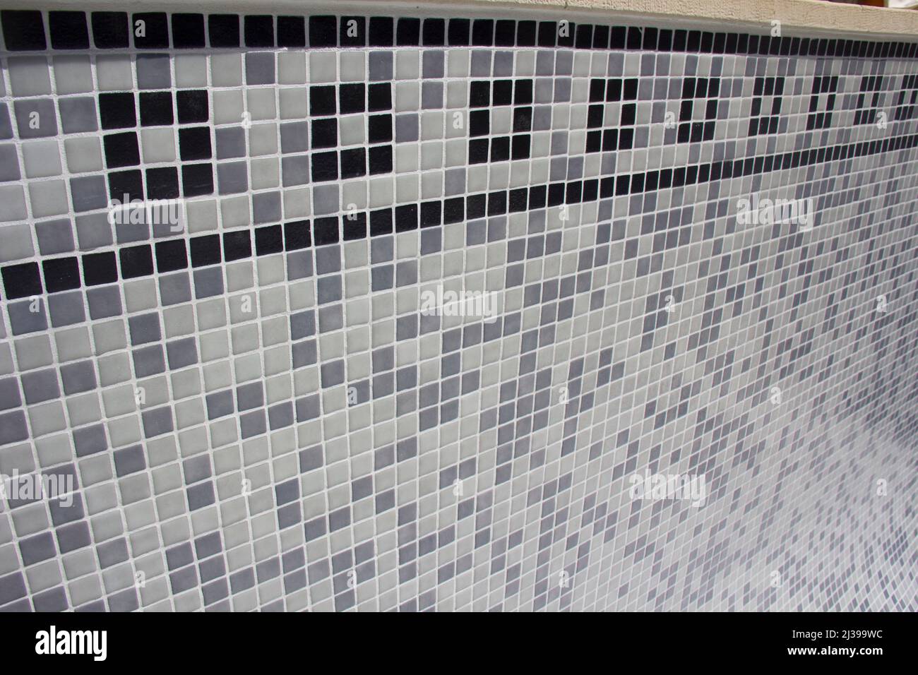 Tiles being applied to refurbish a swimming pool with new grouting ...