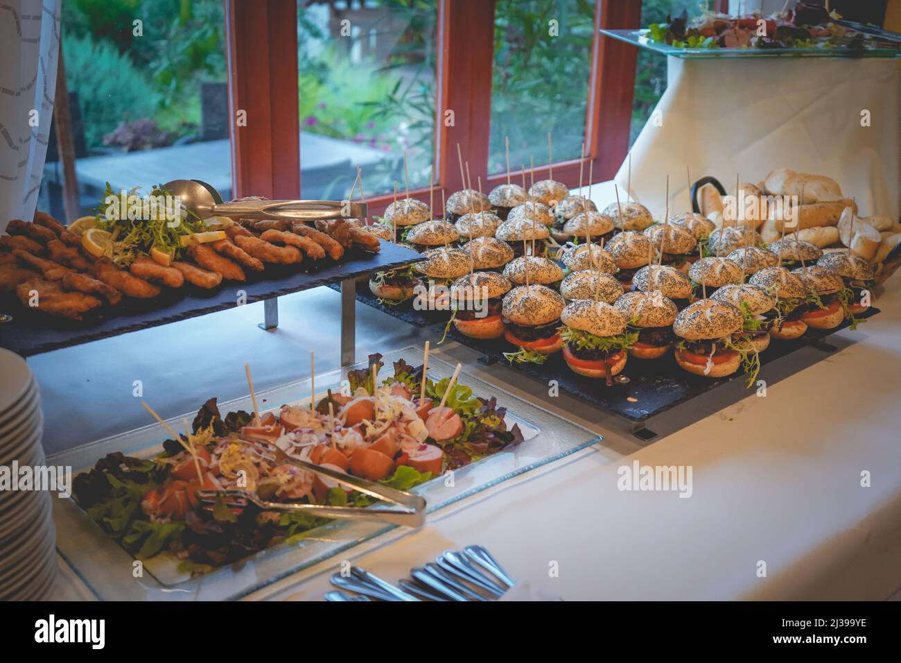 A closeup of a buffet reception table with delicious snacks and burgers ...