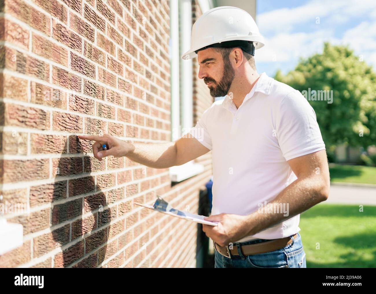 man with a white hard hat holding a clipboard, inspect house Stock ...
