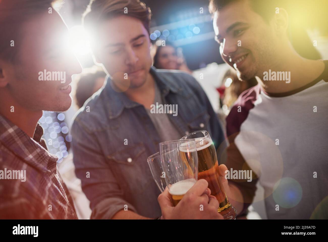 Cheers boys. Cropped shot of guys toasting with beers at a party Stock ...