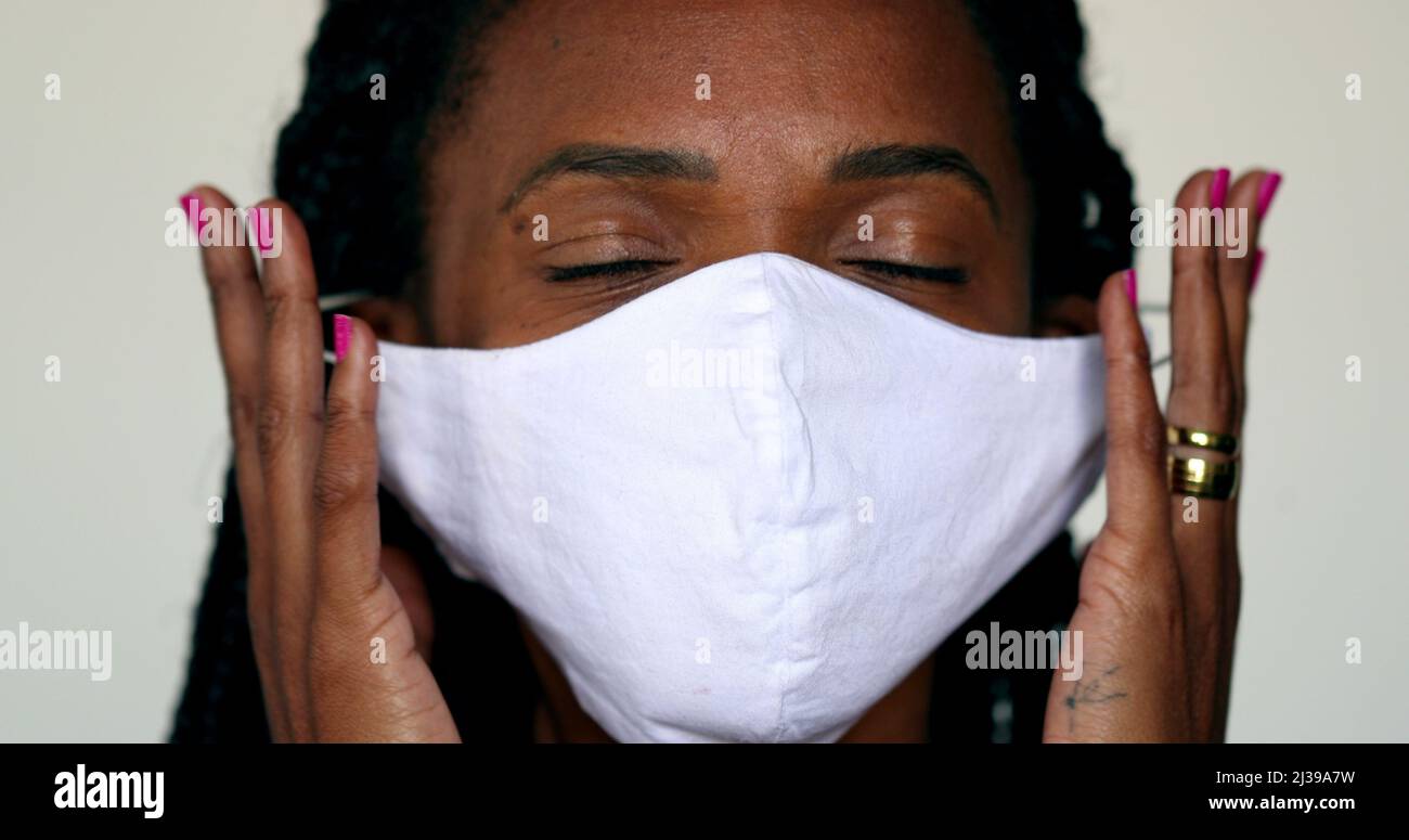 Black Woman removing face mask feeling relief. African person taking ...