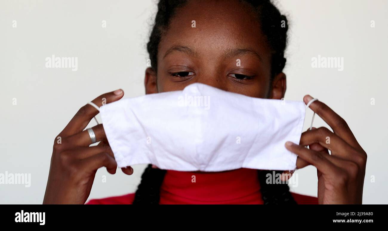 Black girl putting covid-19 face mask Stock Photo - Alamy
