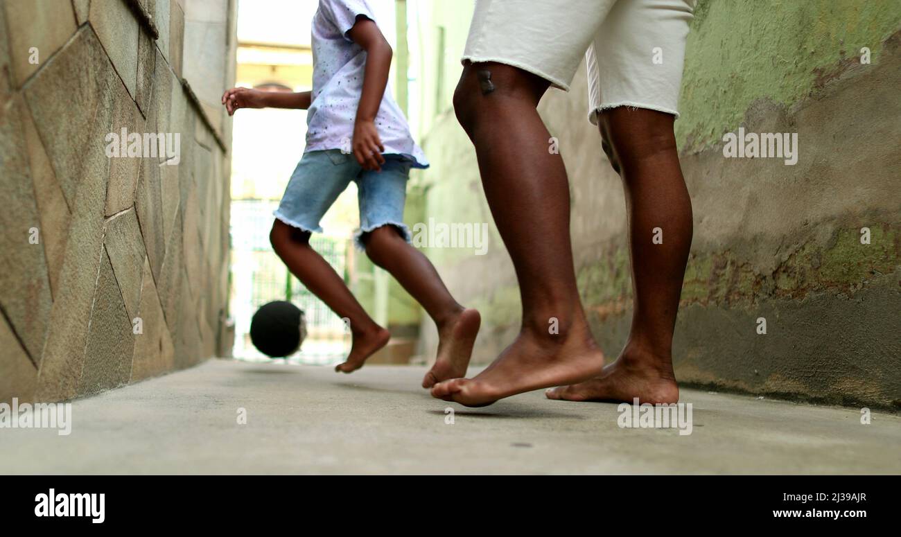 Father and son playing football together. African parent bonding with ...