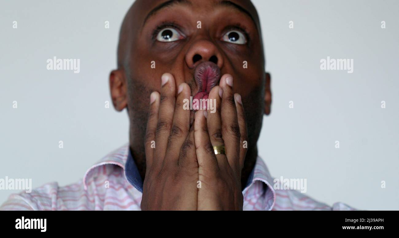 Neurotic anxious black African man looking at camera in desperation and ...