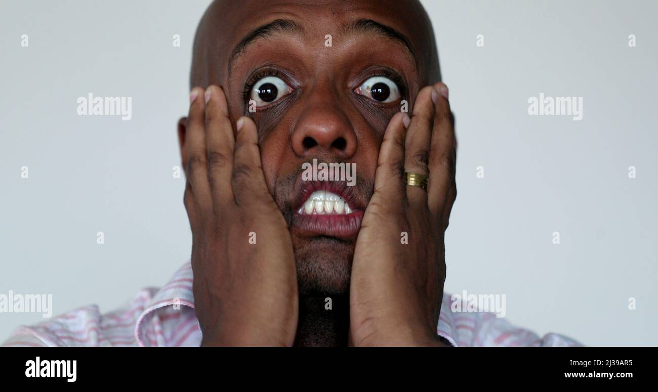 Neurotic anxious black African man looking at camera in desperation and ...