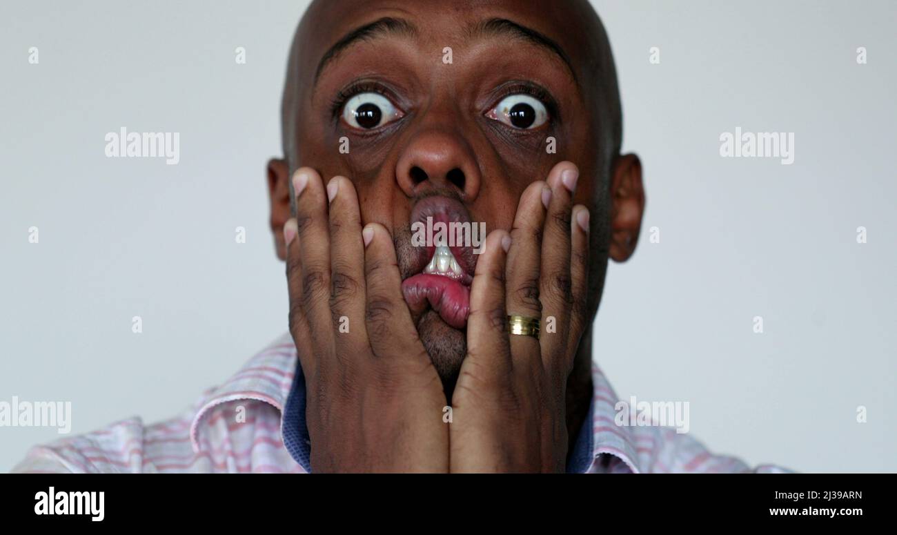 Neurotic anxious black African man looking at camera in desperation and ...
