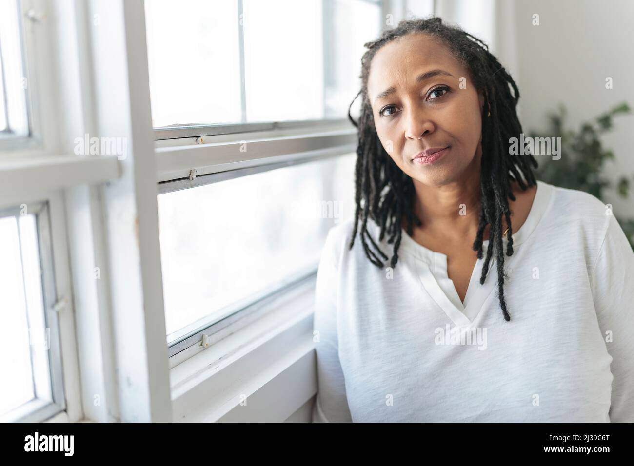 Portrait of an african woman close to a window look worry Stock Photo ...