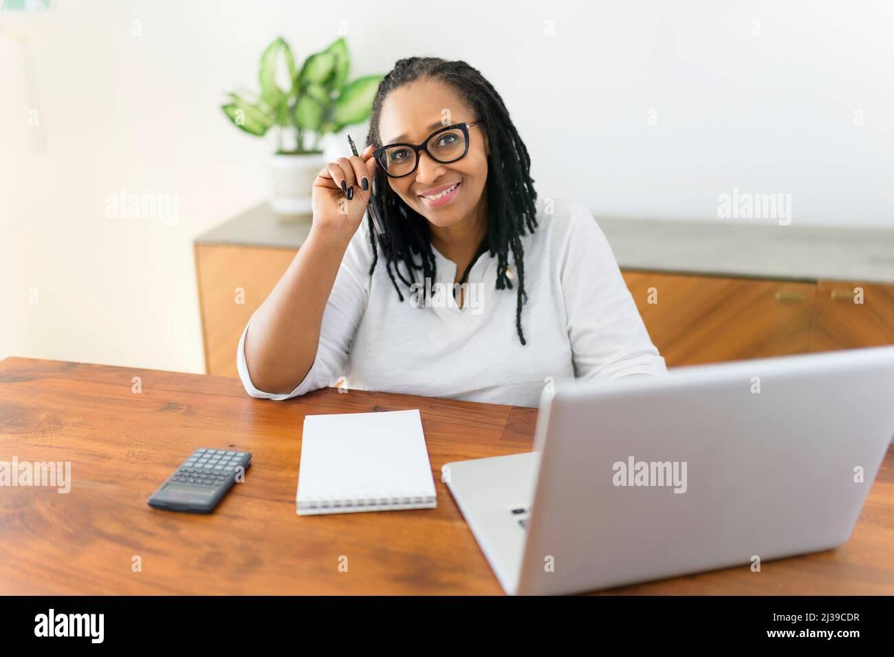 black woman using computer in modern kitchen interior Stock Photo - Alamy