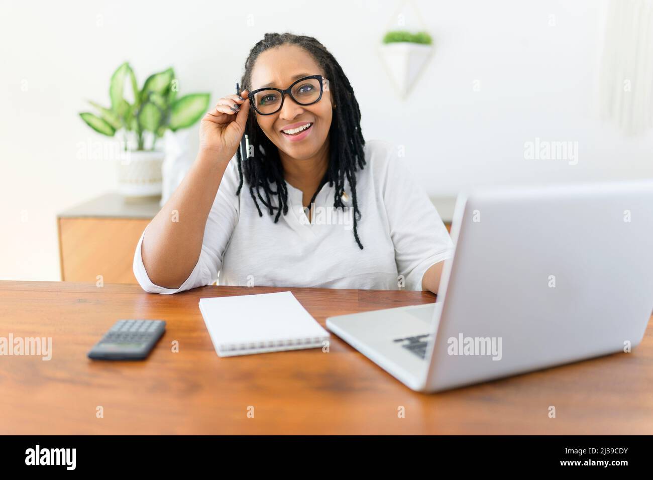 black woman using computer in modern kitchen interior Stock Photo - Alamy